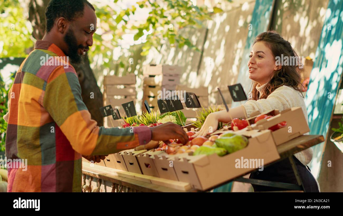 Team of vendors selling locally grown eco produce to diverse people ...