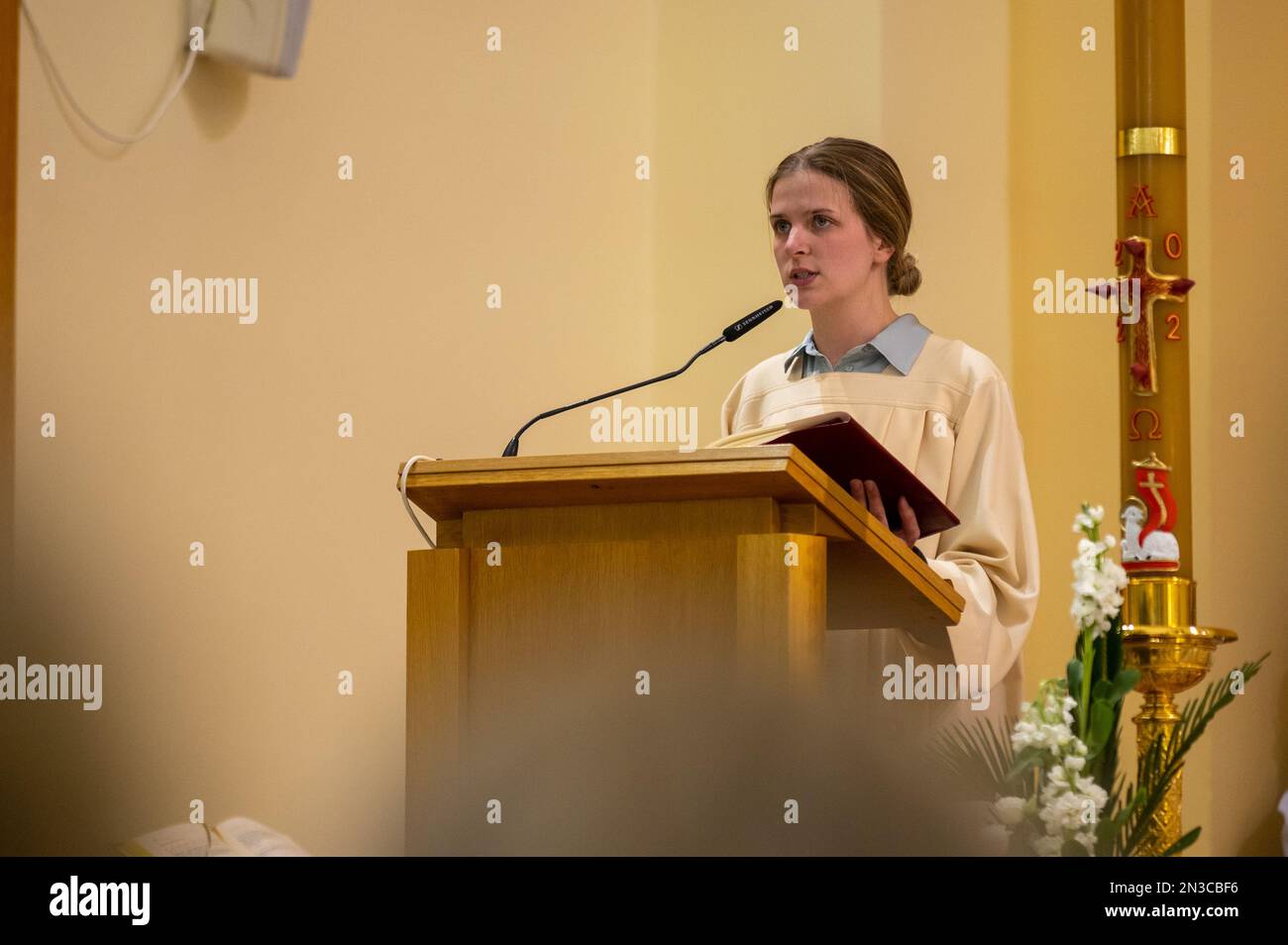 A young woman reading the Scripture during the Holy Mass on the Easter ...