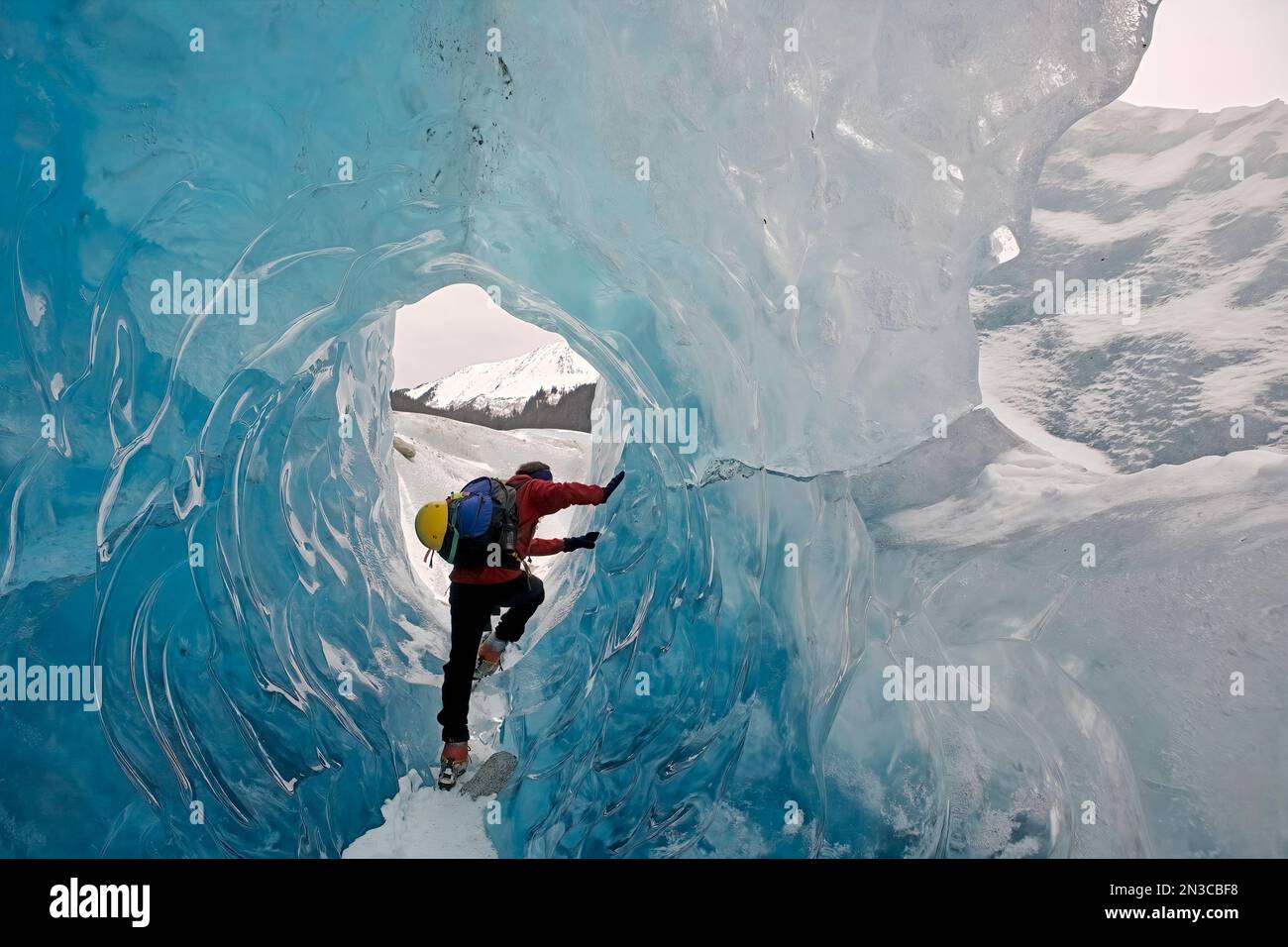 View taken from behind of a hiker, equipped with crampons and emergency ...