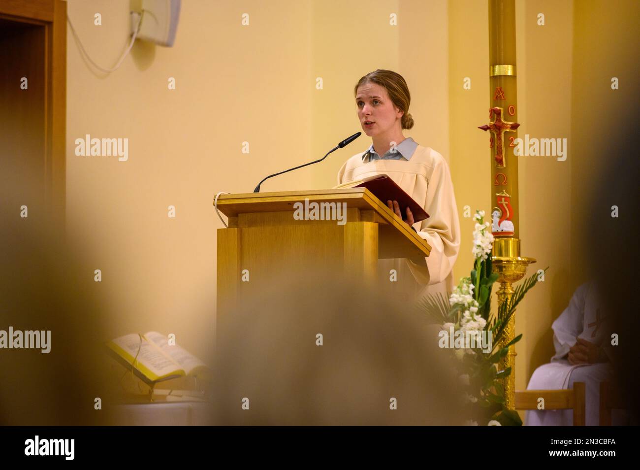 A young woman reading the Scripture during the Holy Mass on the Easter ...