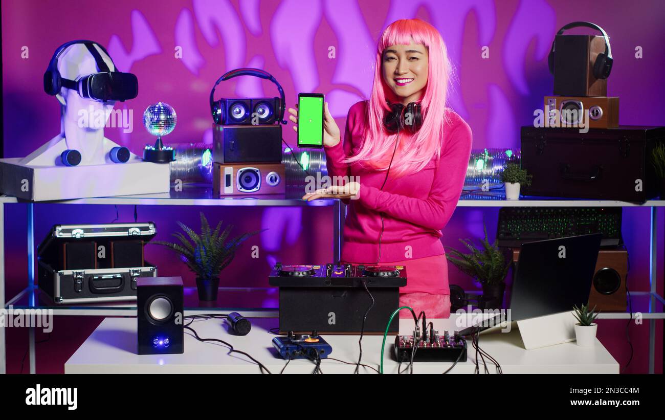 Cheerful artist presenting green screen mock up smartphone with ...