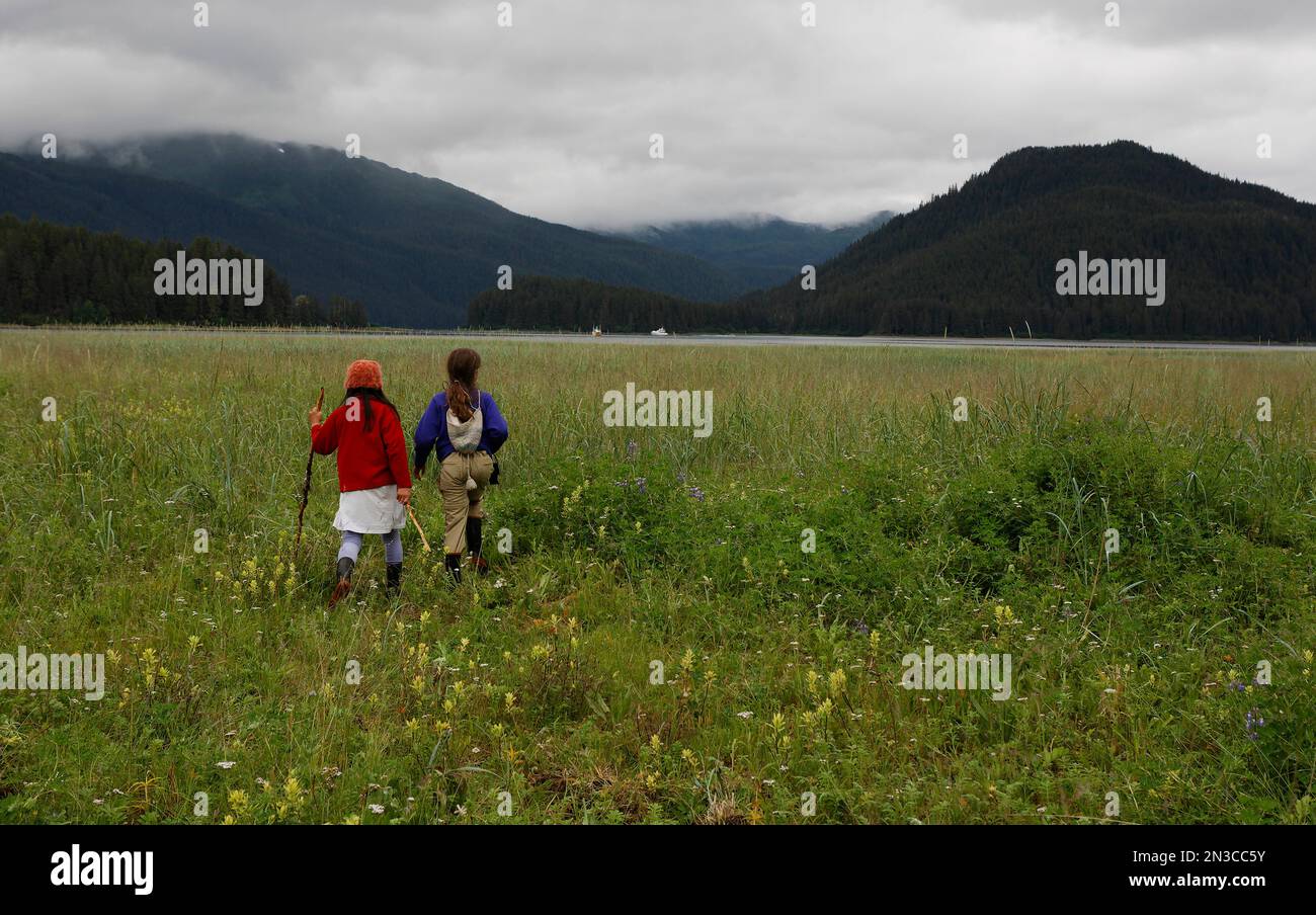 View taken from behind of two young girls hiking through an uplift ...
