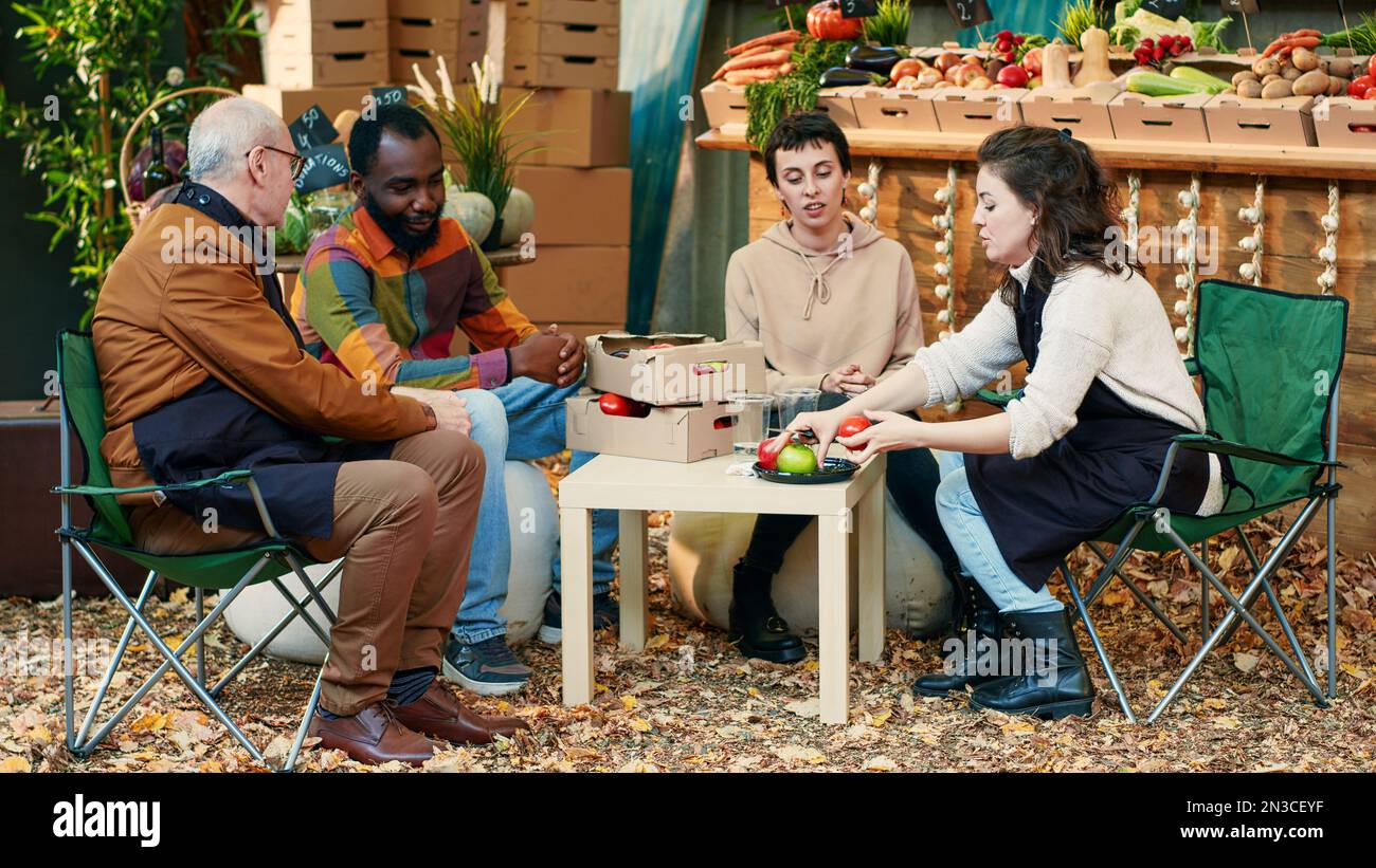 Diverse group of people tasting slices of apples at food fair, having ...