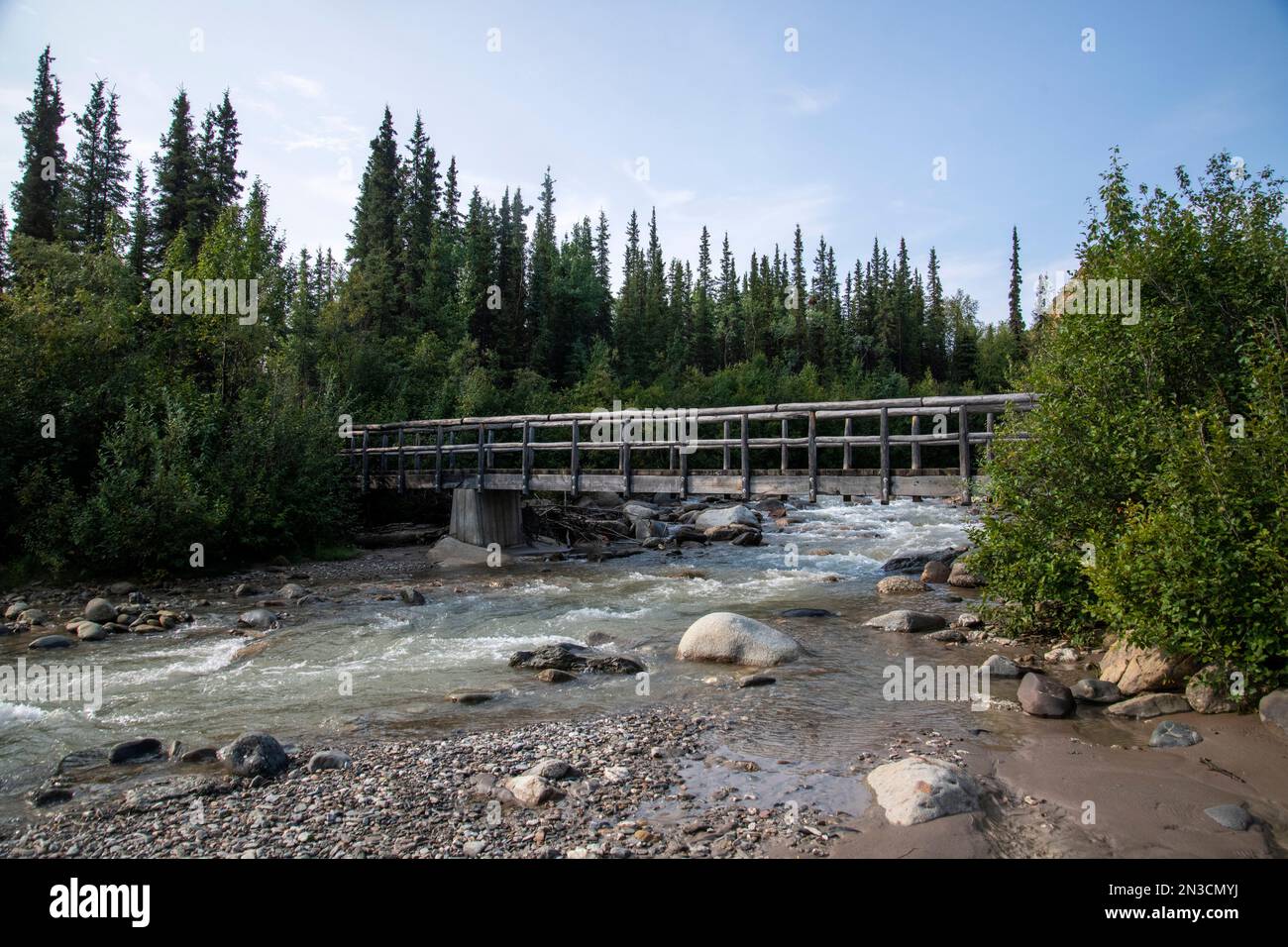 Wooden log bridge crossing over Hines Creek on the Triple Lakes Trail ...
