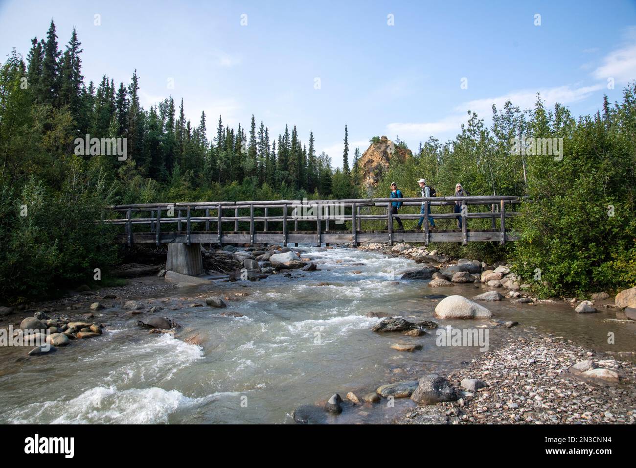 Hikers crossing the Hines Creek Bridge on the Triple Lakes Trail ...