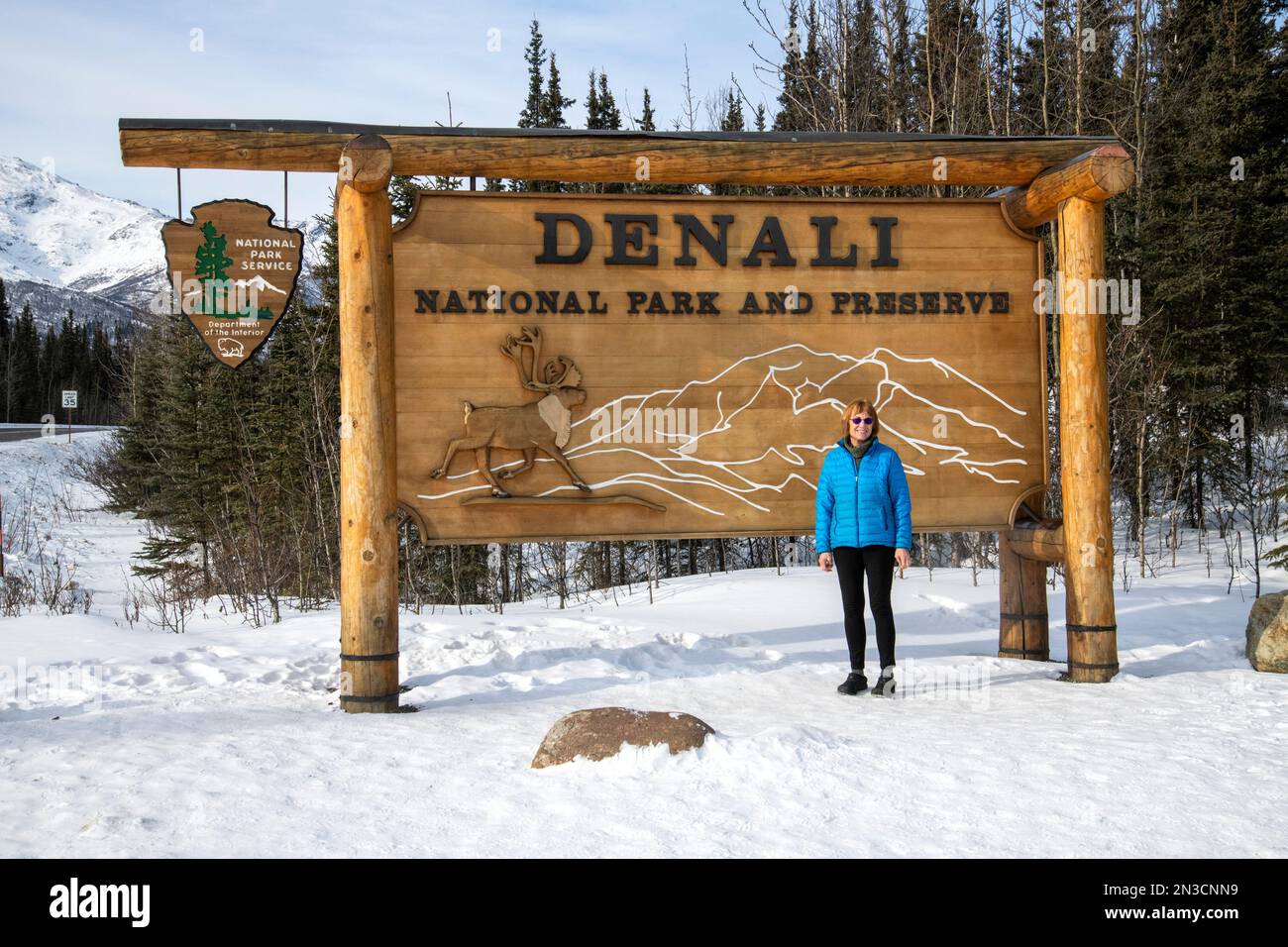 Portrait of a woman tourist standing in front of the sign at the main ...