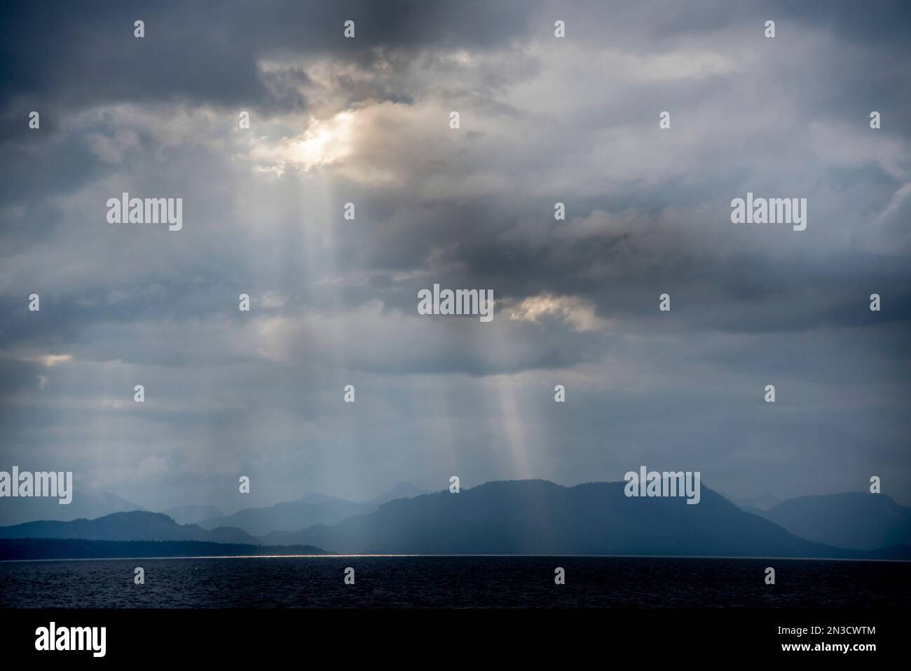 Sunlight breaking through rain clouds in Chatham Strait, in Southeast Alaska; Alaska, United ...