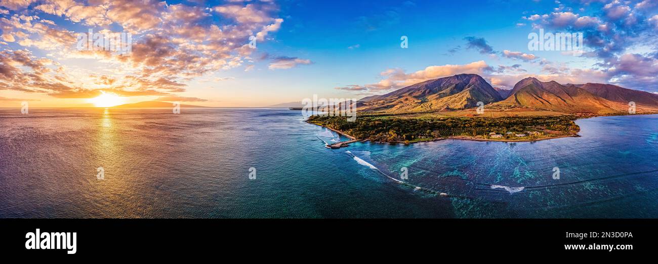 Sunset over the Pacific Ocean warm sunlight illuminating the West Maui ...