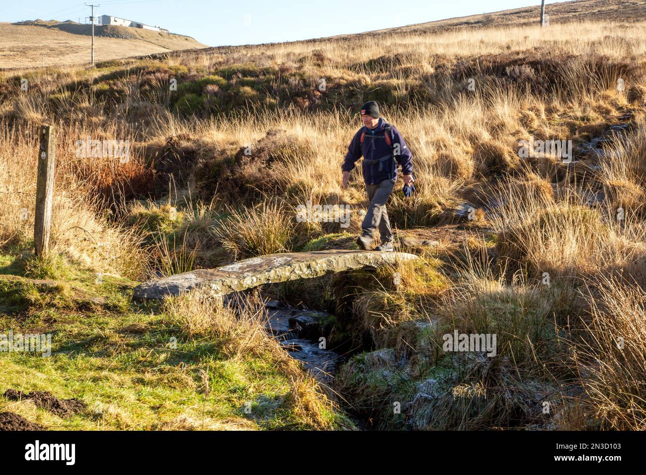 Man walking over an old packhorse bridge near Flash in the ...