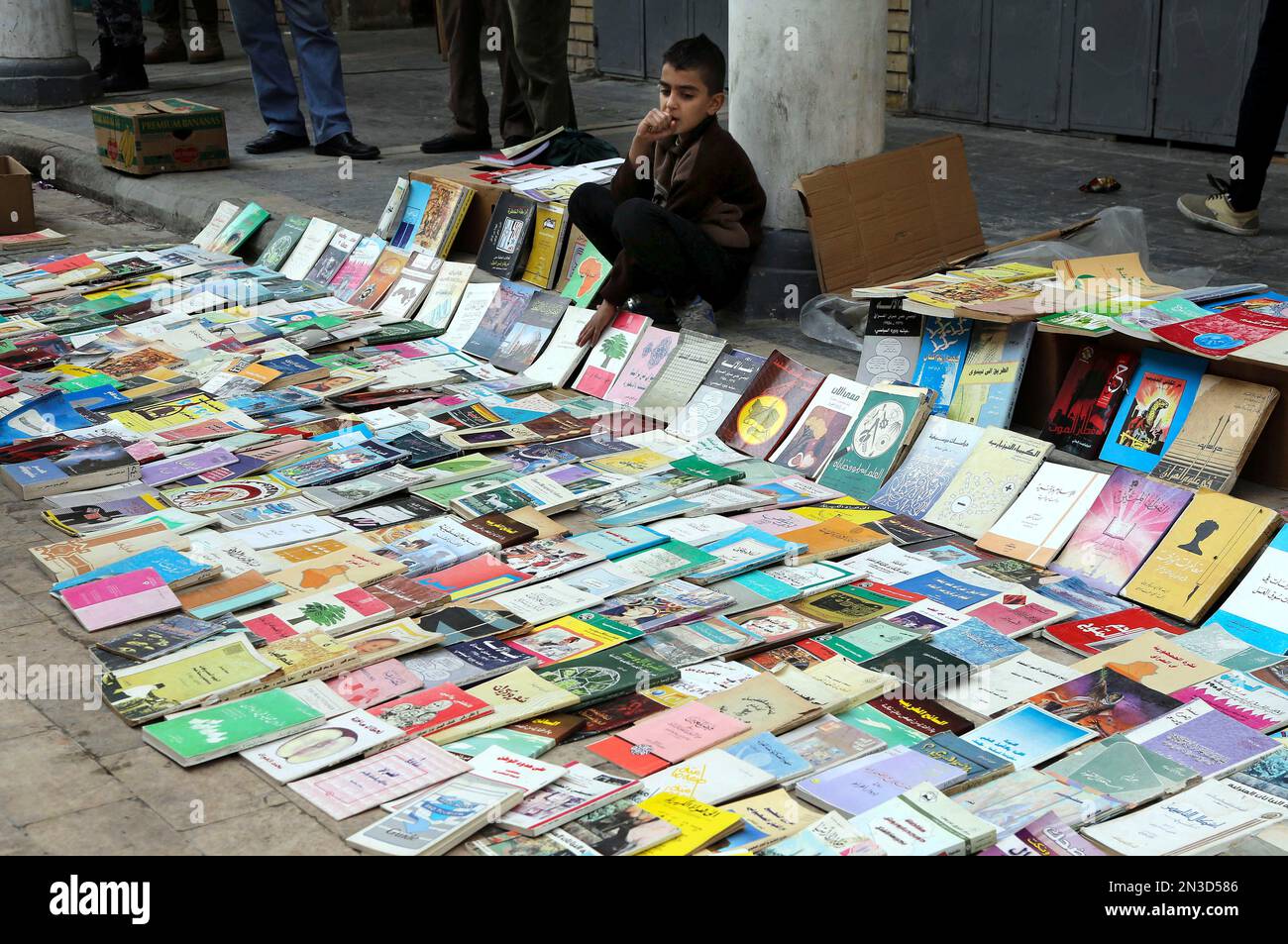 An Iraqi boy waits for customers as he sells used books on al-Mutanabi ...