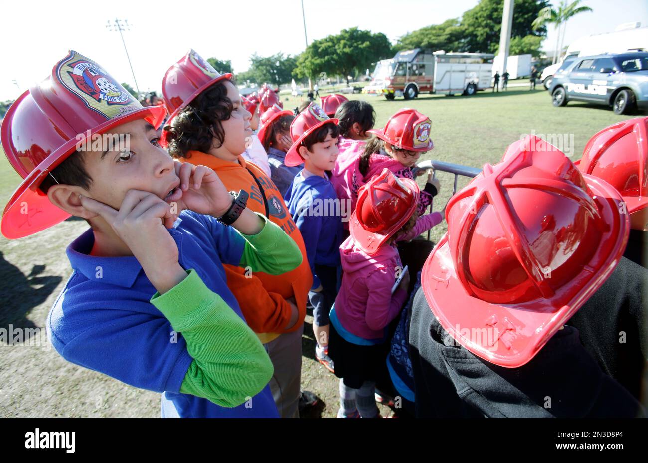 Ricardo Olmedo, left, 5, covers his ears from gun shots as he watches a ...