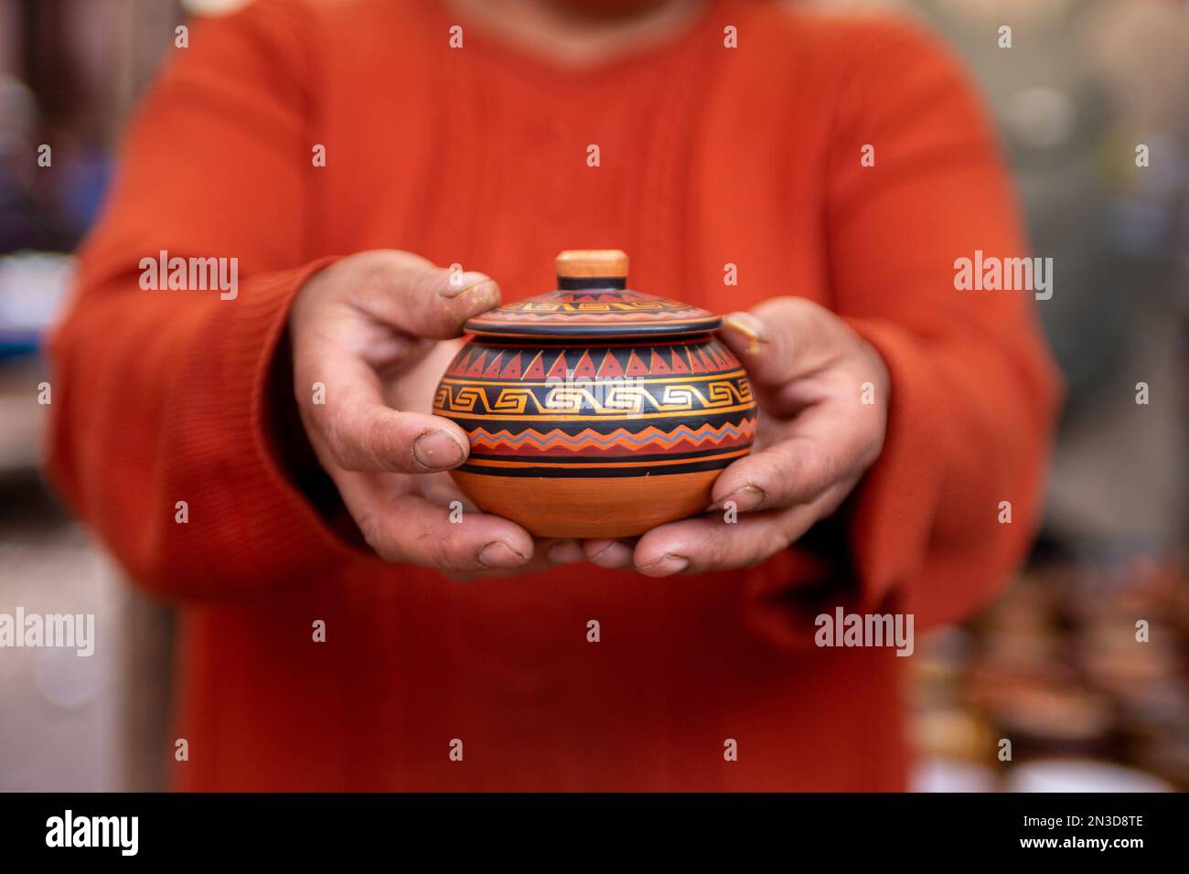 Peruvian Woman Holding souvenir ceramic pottery Stock Photo - Alamy