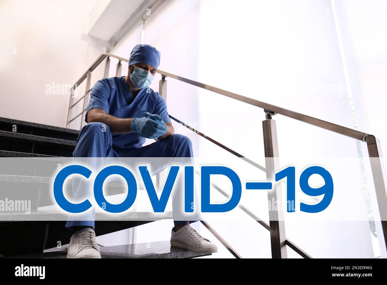 Tired overwhelmed doctor sitting on stairs in hospital. Medical system ...