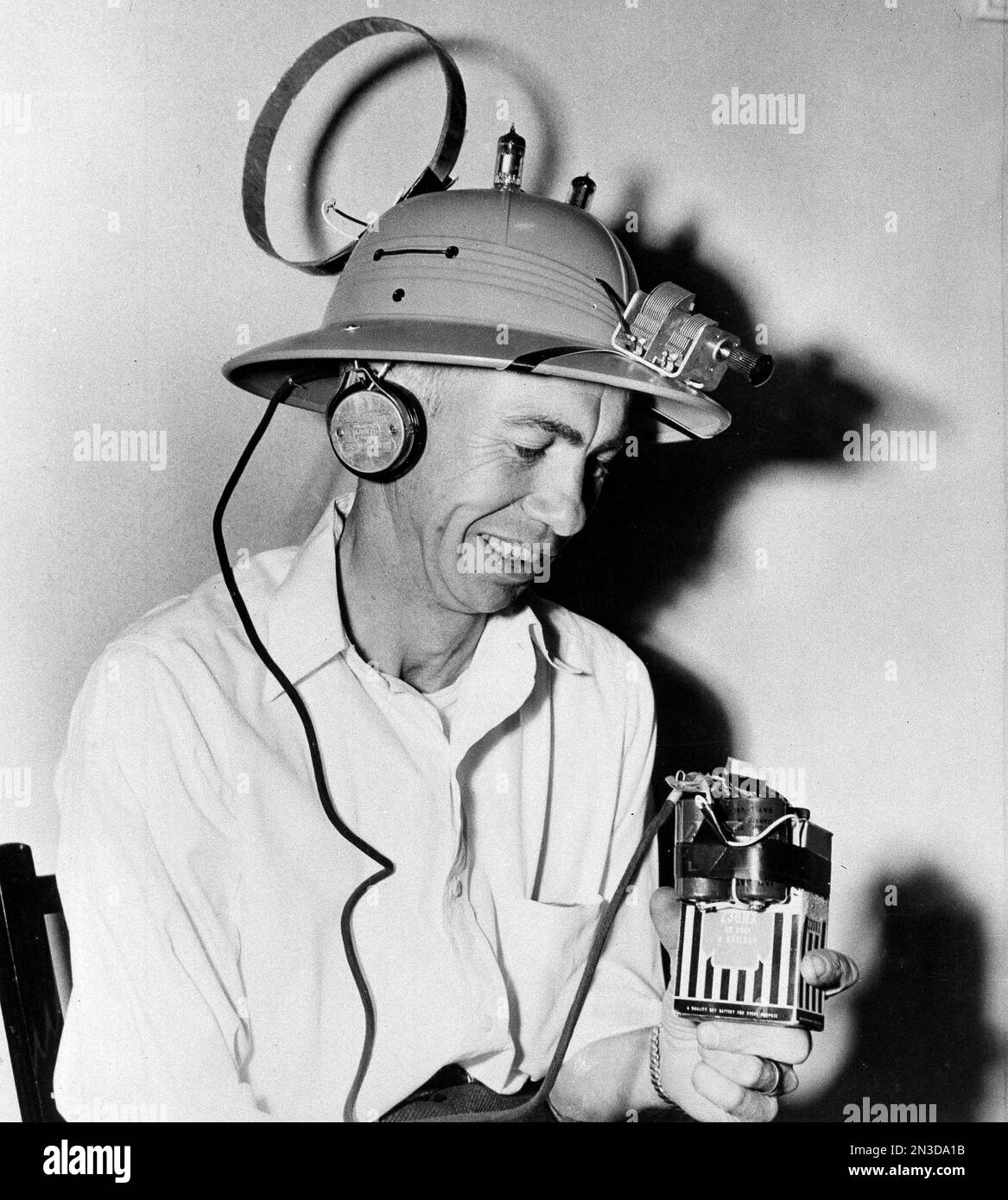 Frank W. Elmore, an electrician, wears a hat radio on his head in ...