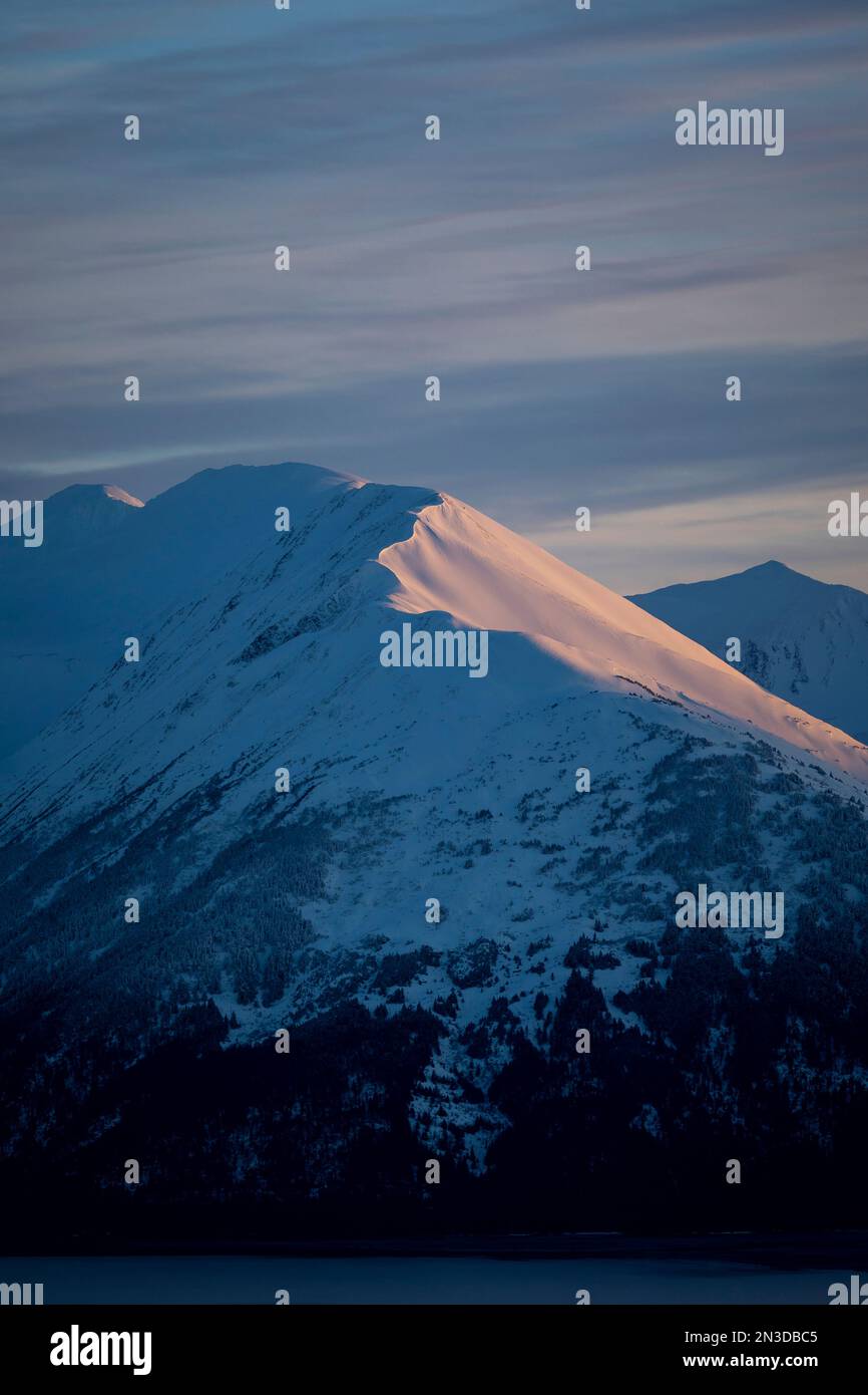 Sunset reflecting on the snow-covered mountaintop at Turnagain Arm ...