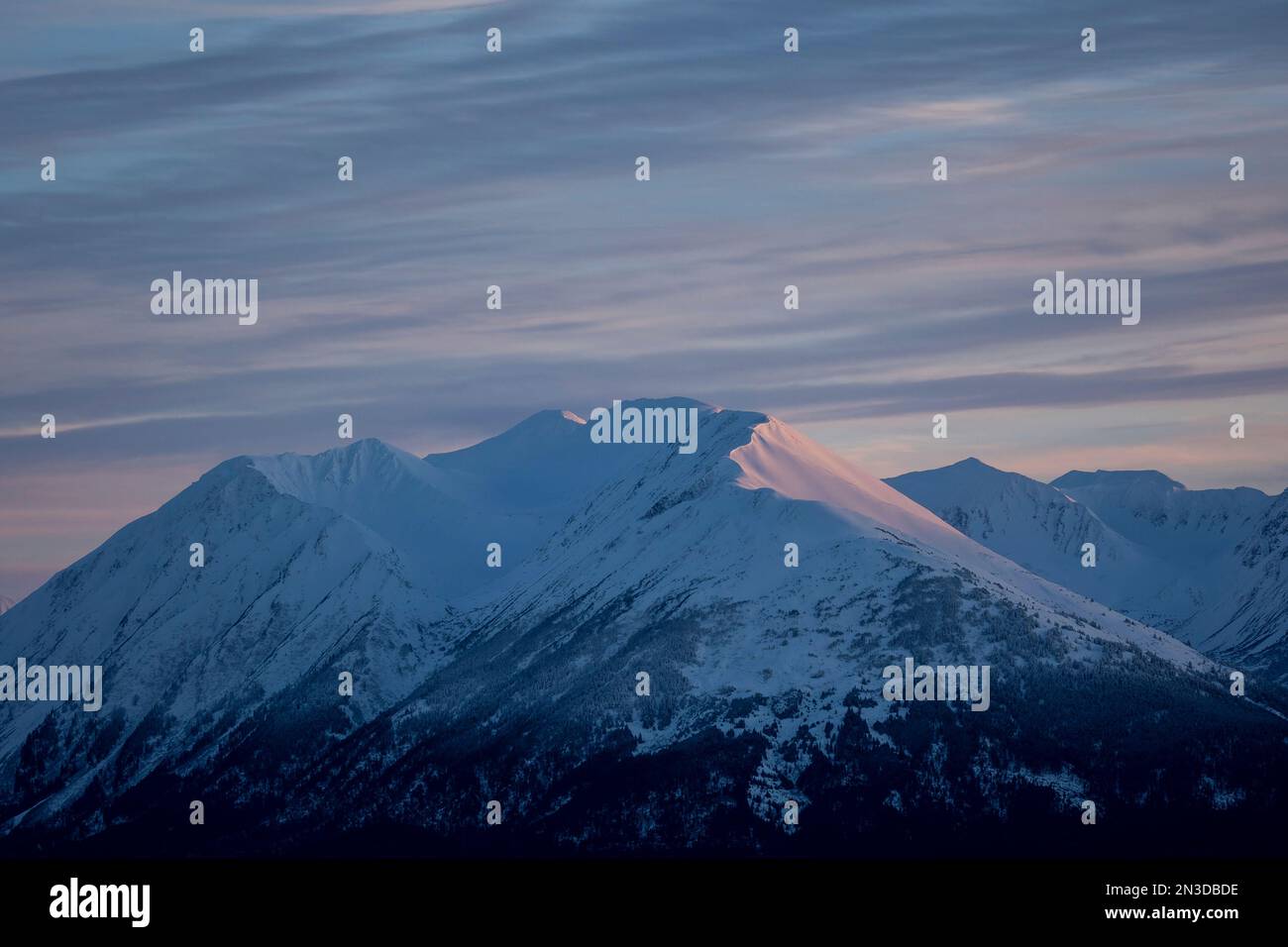 Sunset reflecting on the snow-covered mountaintop at Turnagain Arm ...