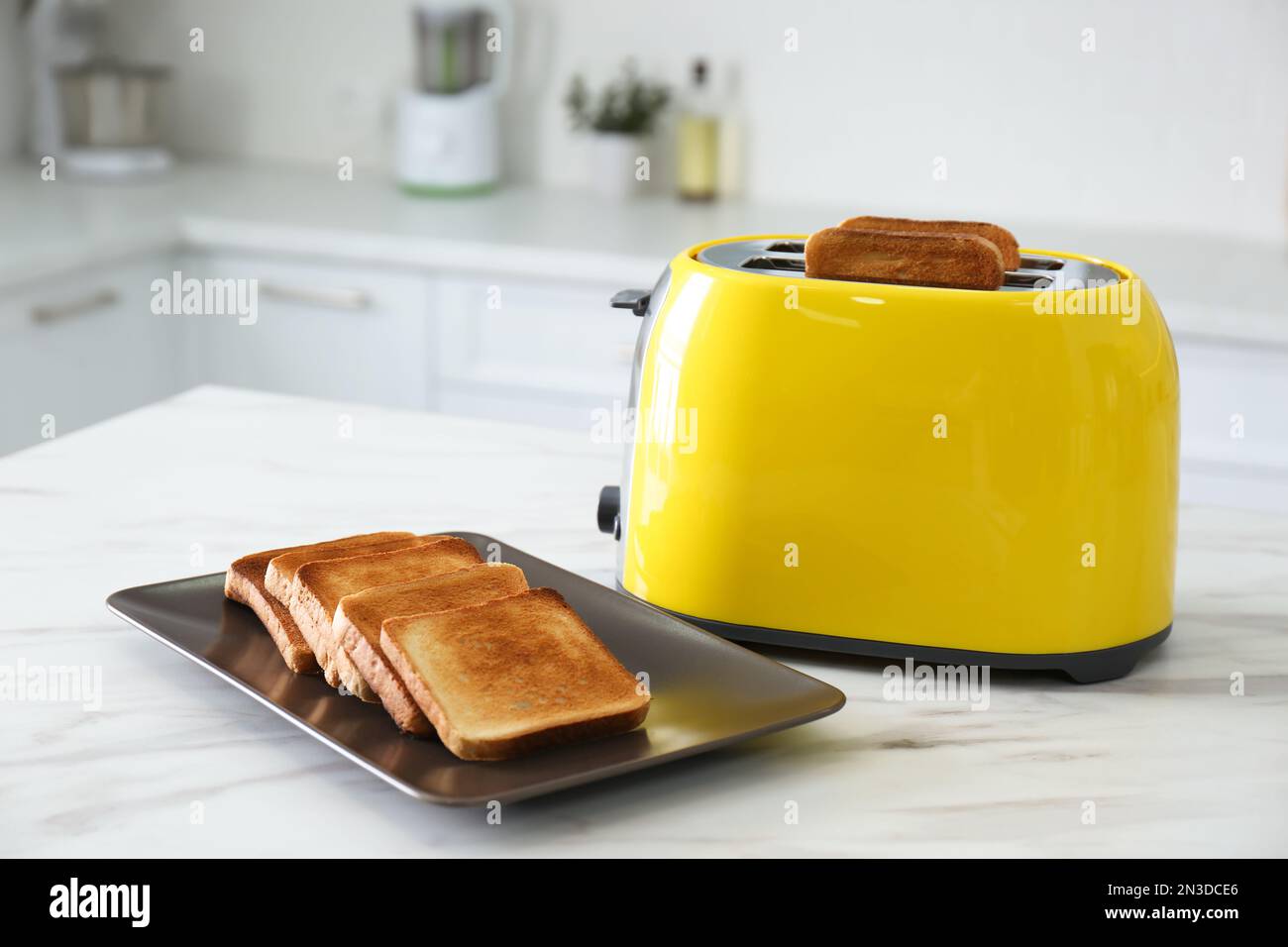 Modern toaster with slices of bread on white marble table in kitchen Stock Photo - Alamy