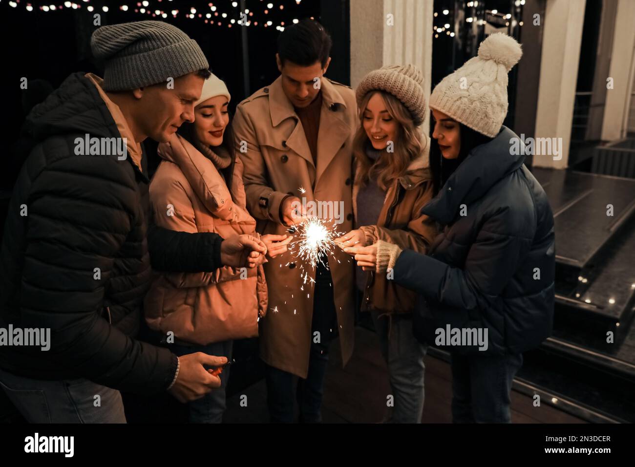 Group of people holding burning sparklers outdoors Stock Photo - Alamy