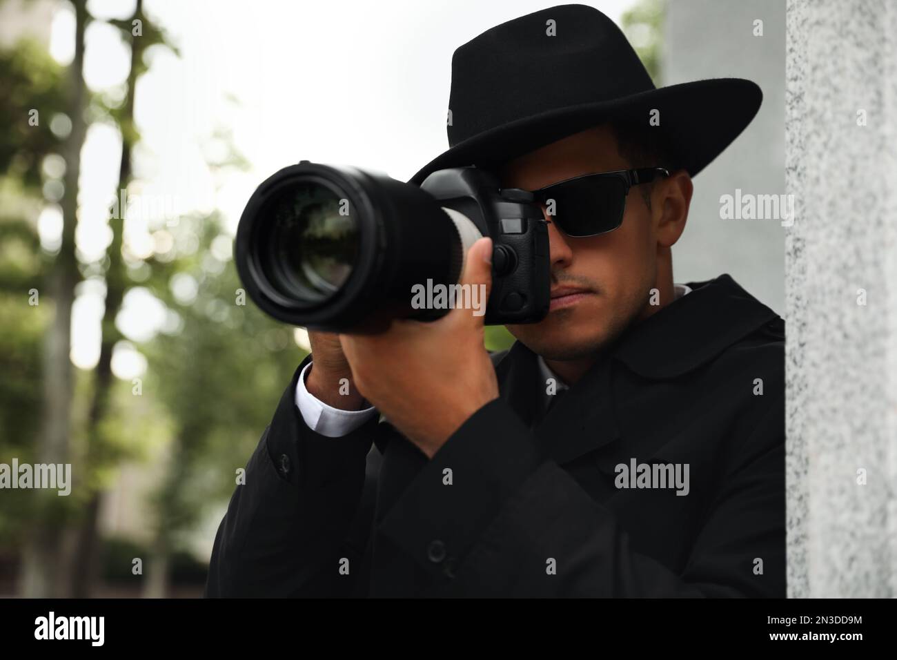 Private detective with modern camera spying on city street Stock Photo ...