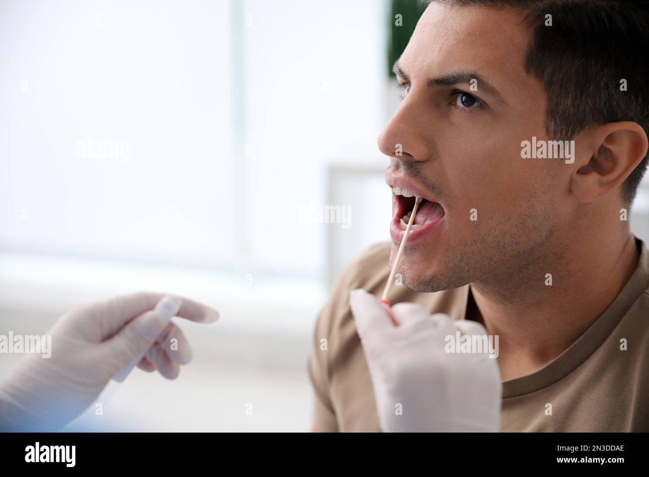 Doctor taking sample for DNA test from man in clinic Stock Photo - Alamy