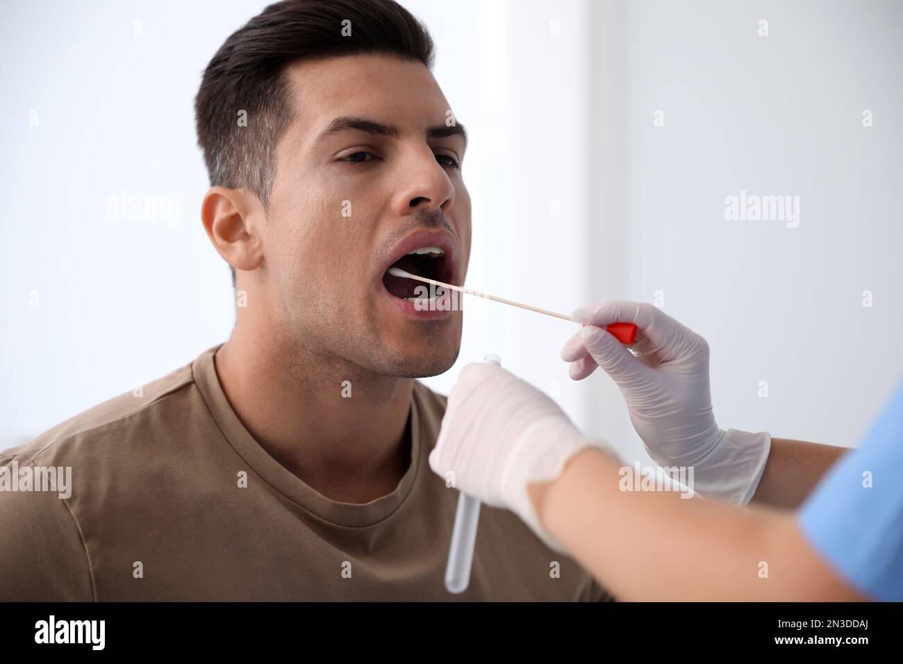 Doctor taking sample for DNA test from man in clinic Stock Photo - Alamy