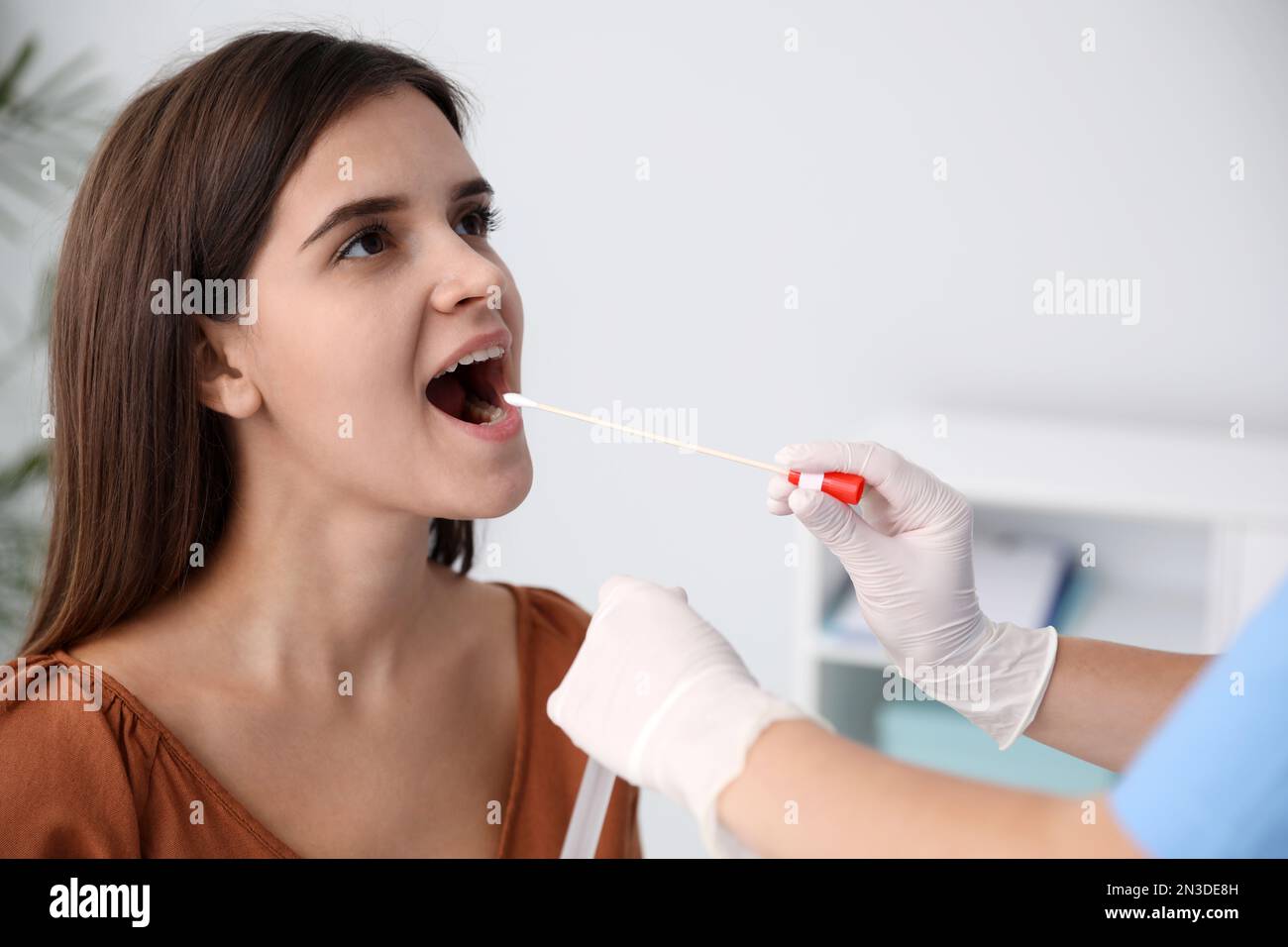 Doctor taking sample for DNA test from woman in clinic Stock Photo - Alamy