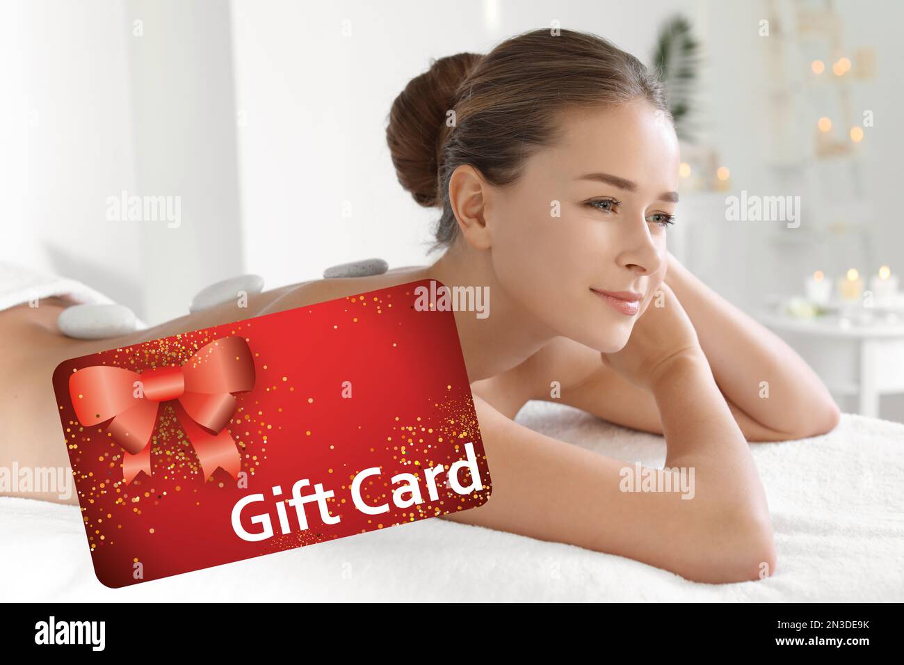 Spa salon gift card. Happy young woman having hot stone massage Stock ...