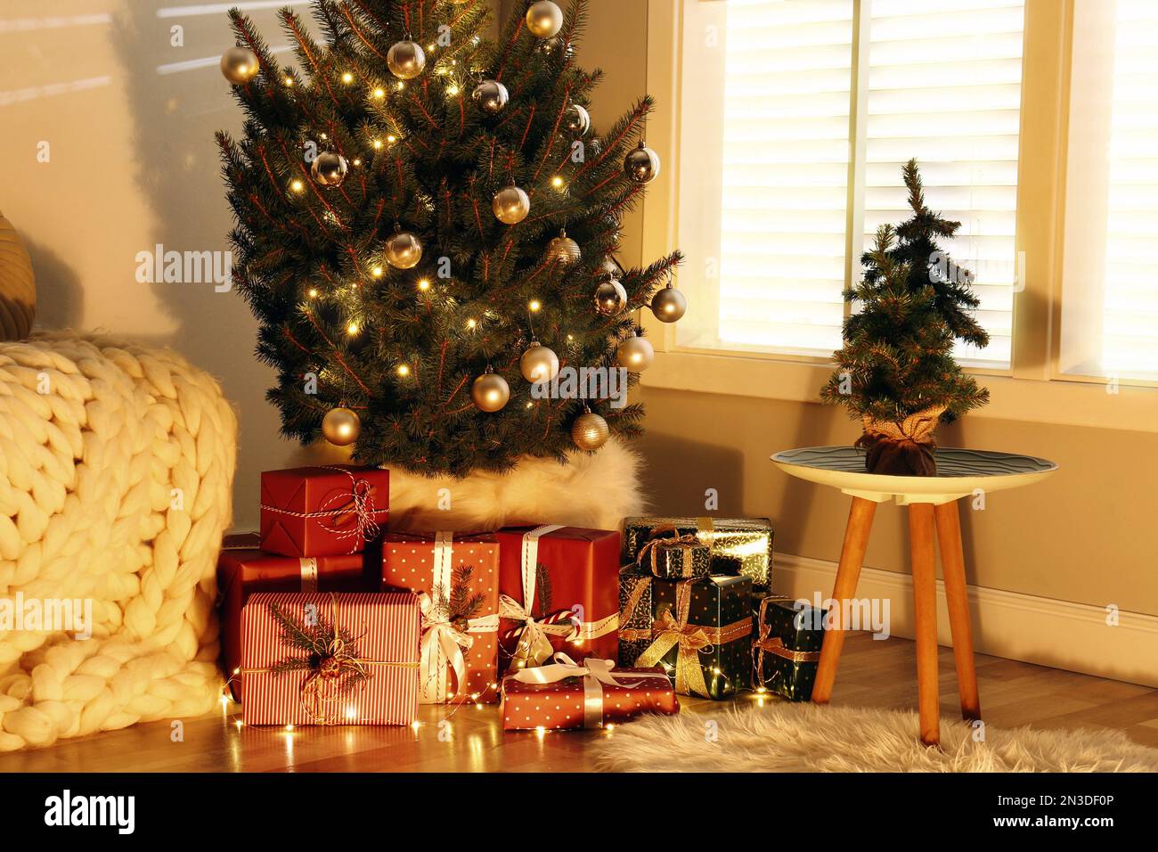Beautiful Christmas tree and gift boxes near window in room. Interior ...