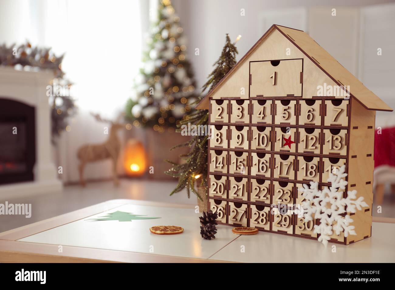 Wooden house shaped Advent calendar in room decorated for New Year ...