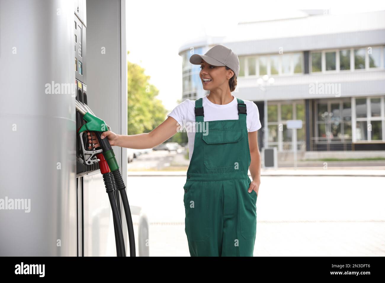 Worker taking fuel pump nozzle at modern gas station Stock Photo - Alamy
