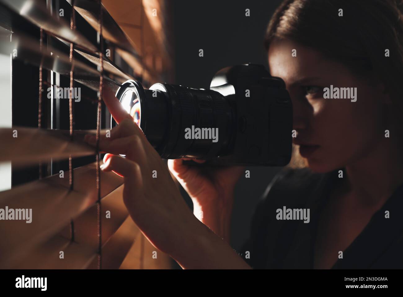 Private detective with camera spying near window indoors Stock Photo ...