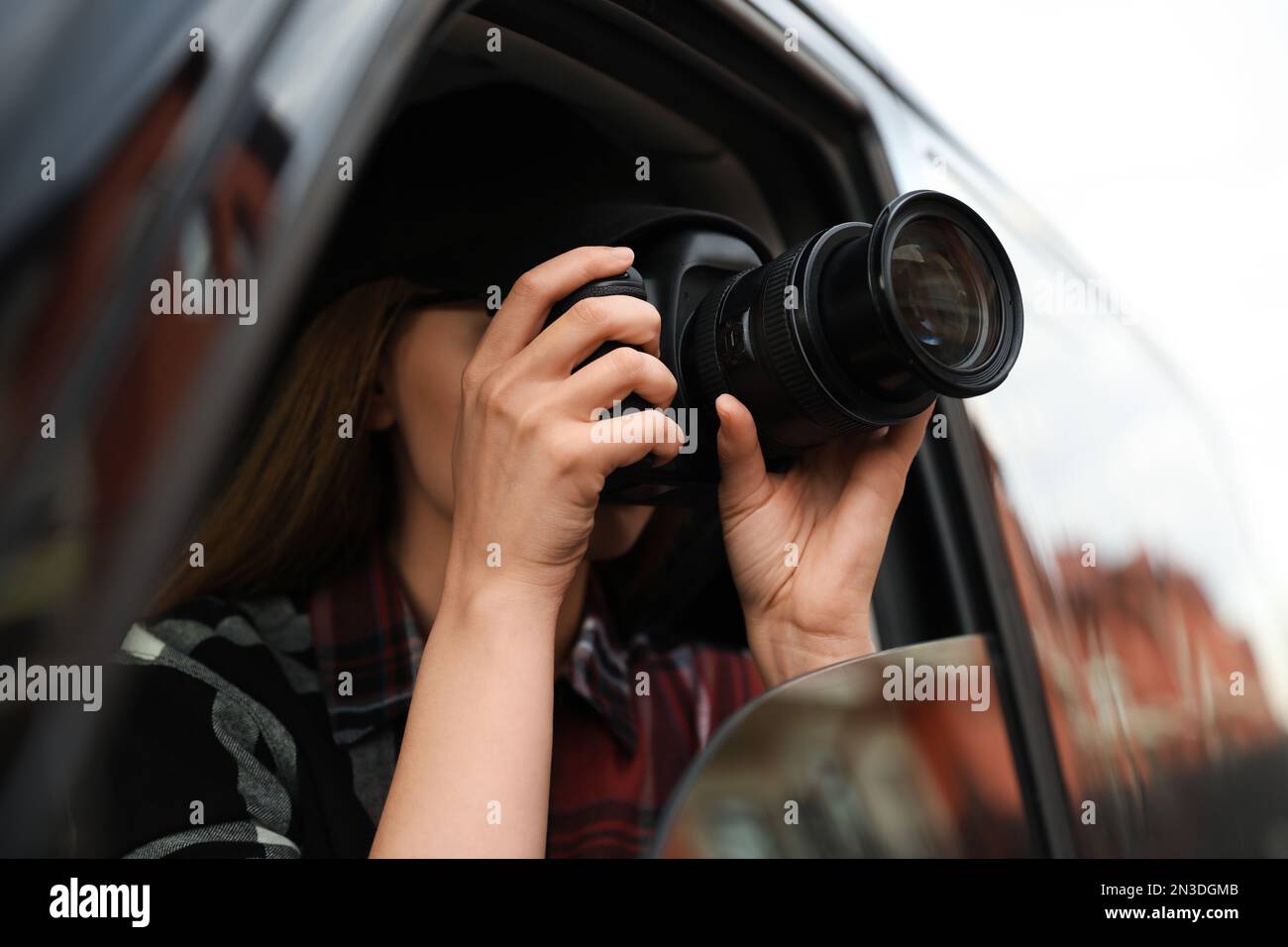 Private detective with camera spying from car Stock Photo - Alamy
