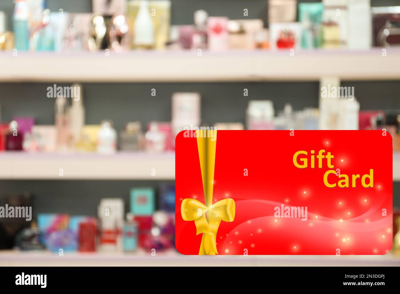 Store gift card. Blurred view of shelves with perfume bottles in shop ...