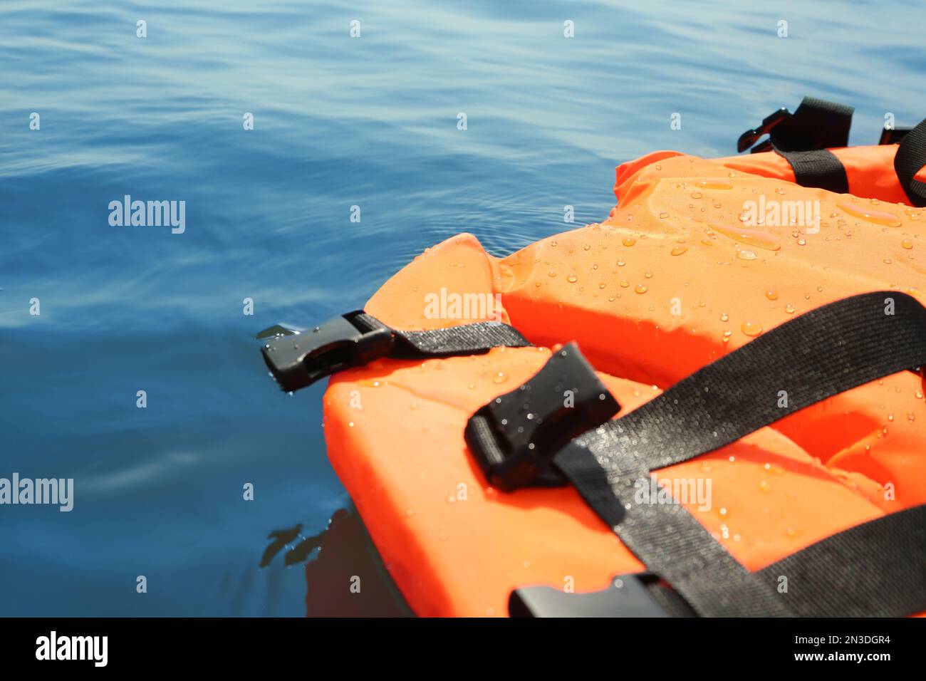 Orange life jacket floating in sea, closeup. Emergency rescue equipment ...