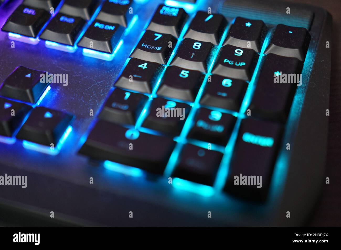 A closeup of computer's keyboard with blue light Stock Photo - Alamy