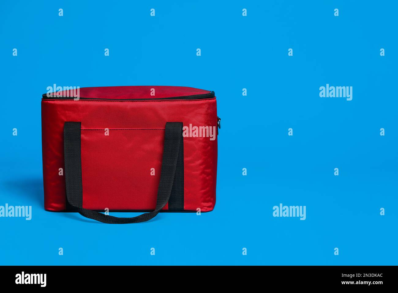 Modern red thermo bag on light blue background. Space for text Stock ...