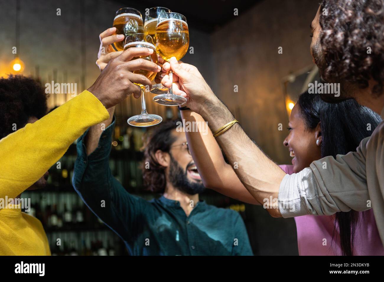 Young group of multiracial people toasting cold beer at happy hours ...