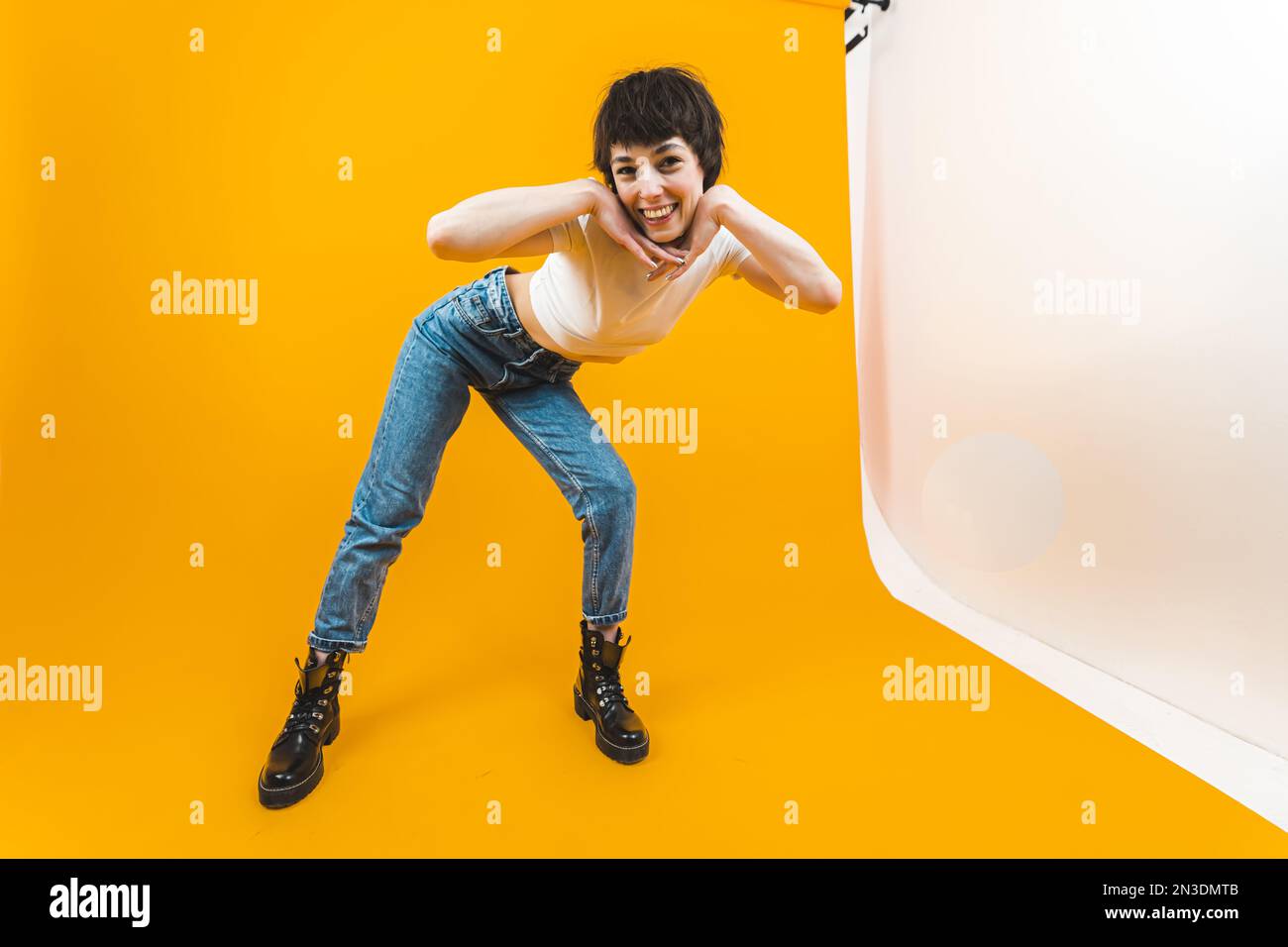 Fashion female model in casual clothing posing by leaning her body ...