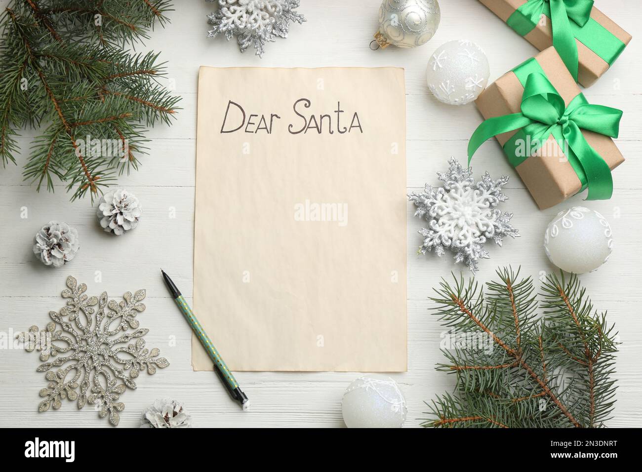Flat lay composition with letter saying Dear Santa on white wooden ...
