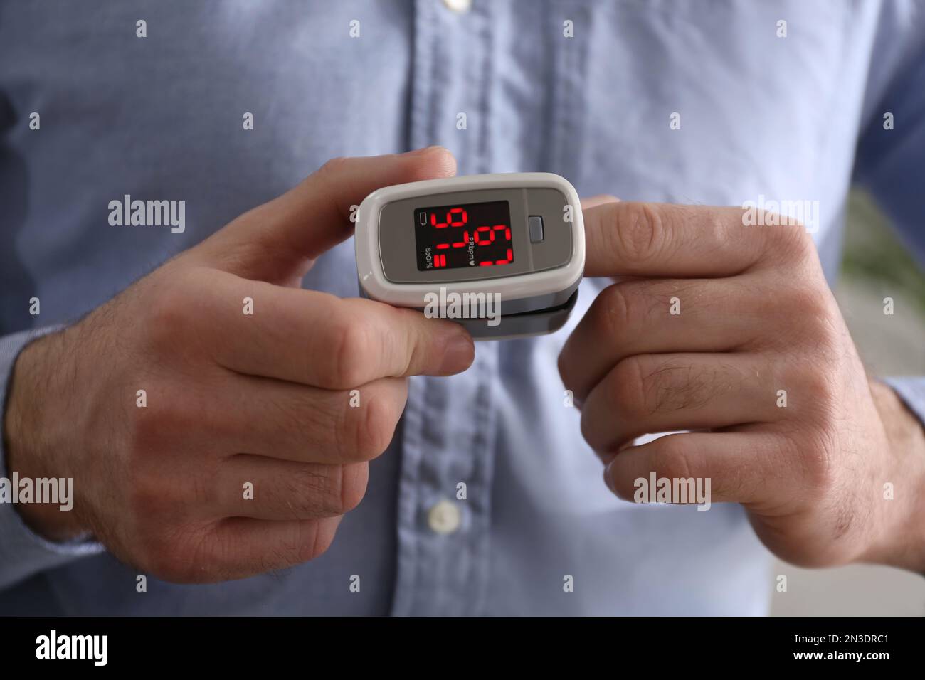 Man measuring oxygen level with modern fingertip pulse oximeter ...