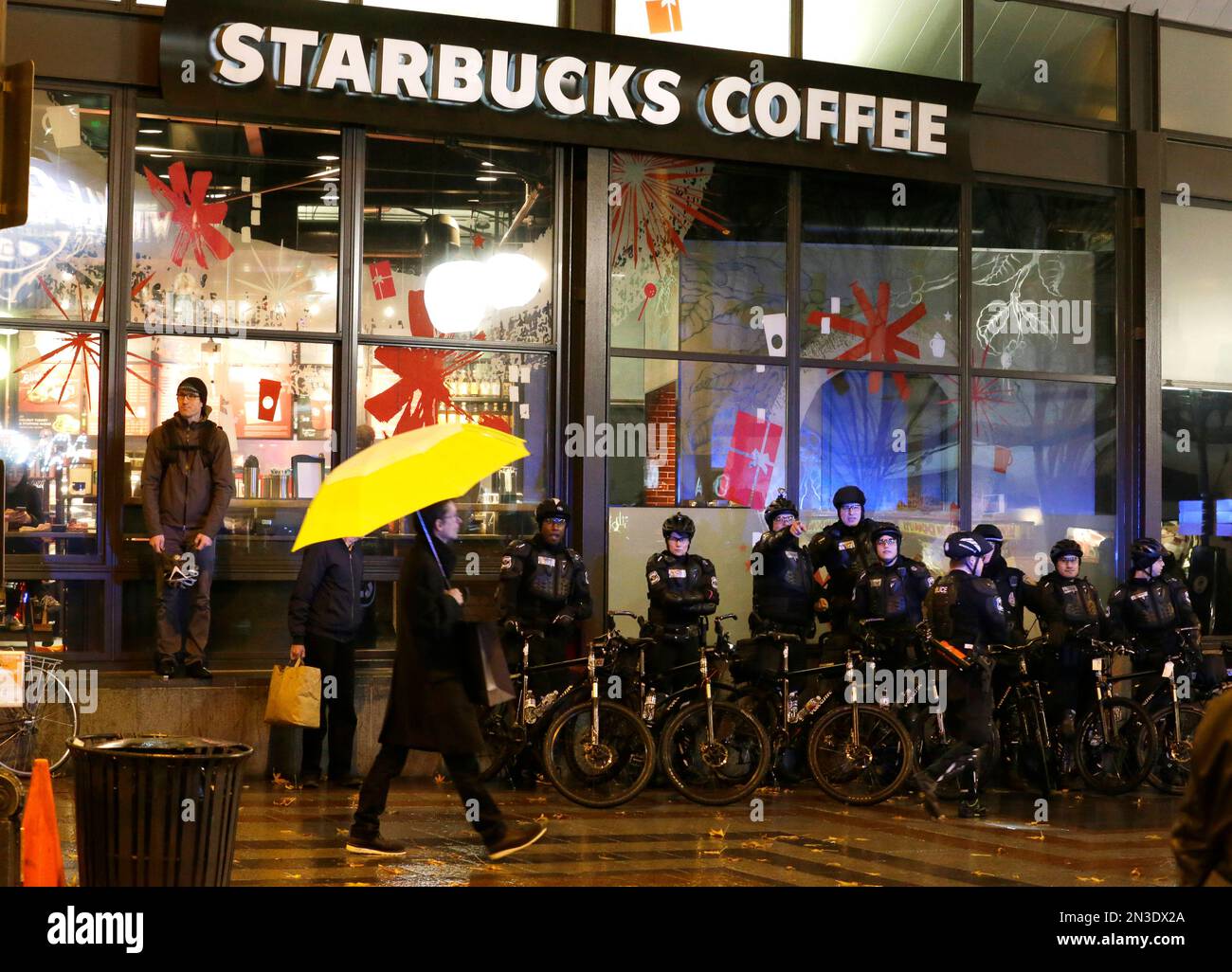 Bicycle police watching over a protest stand next to a Starbucks coffee ...