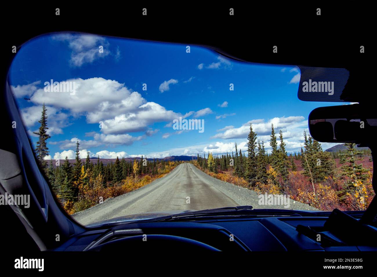 View through the front window of a car, of the Fall foliage along the ...