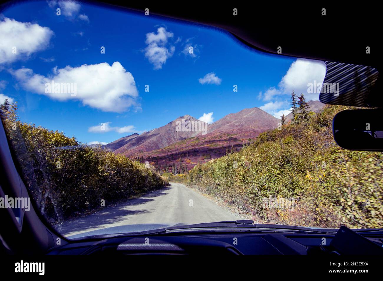 View through the front window of a car, of the Fall foliage along the ...