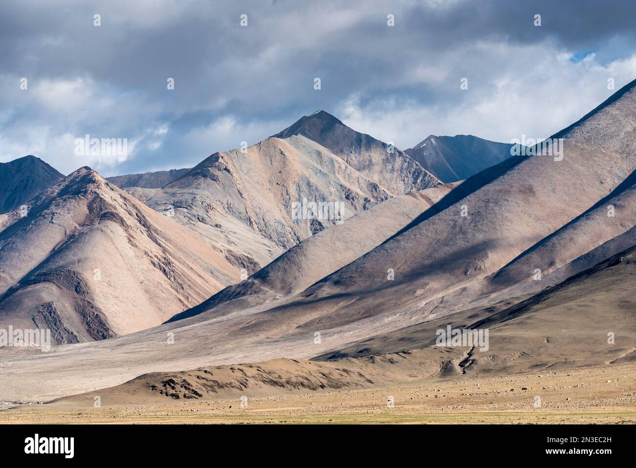 View of the Tibetan plateau with stark mountain peaks and slopes ...