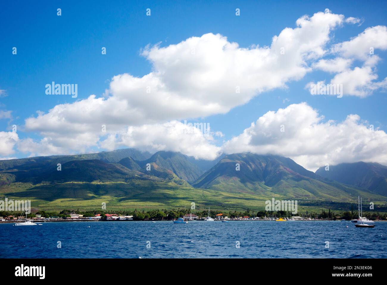Boats moored off shore in the Lahaina Harbor with the West Maui ...