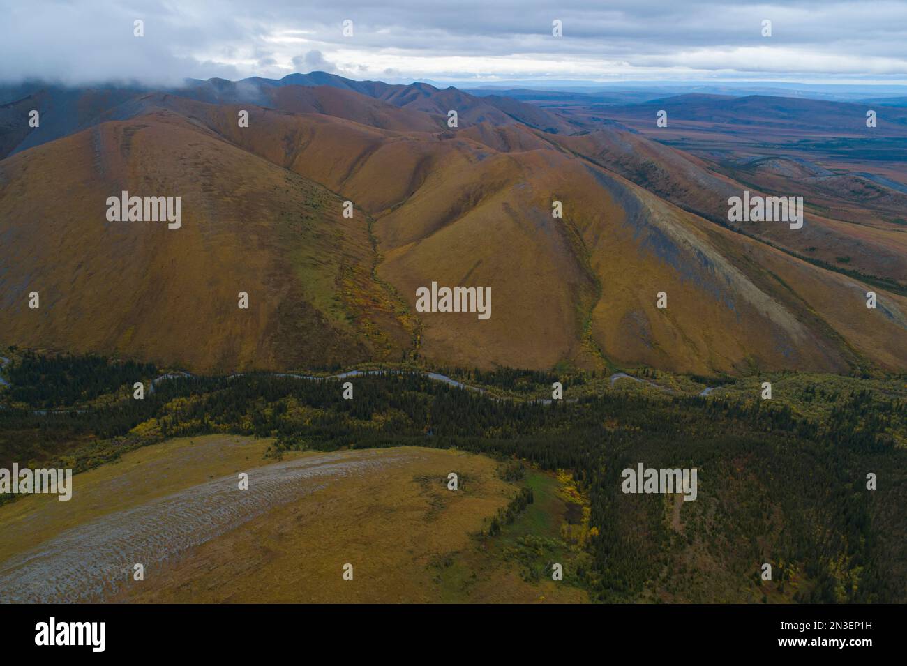 Aerial photograph of a river winding through the Richardson Mountains ...
