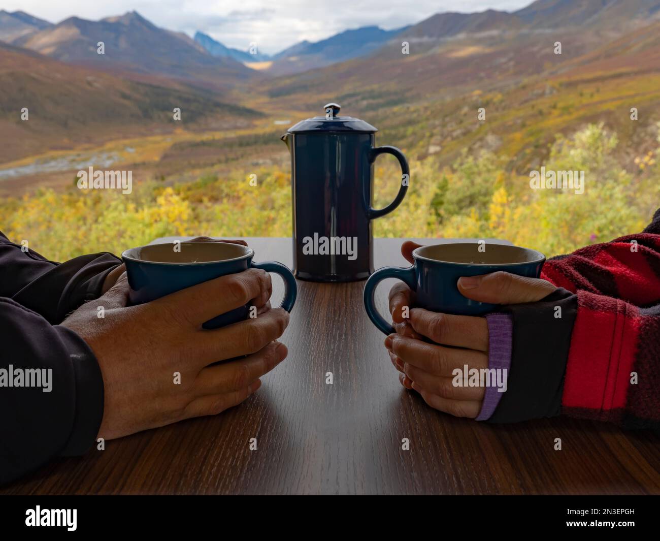 Close-up of couple's hands holding coffee mugs, drinking coffee from a ...