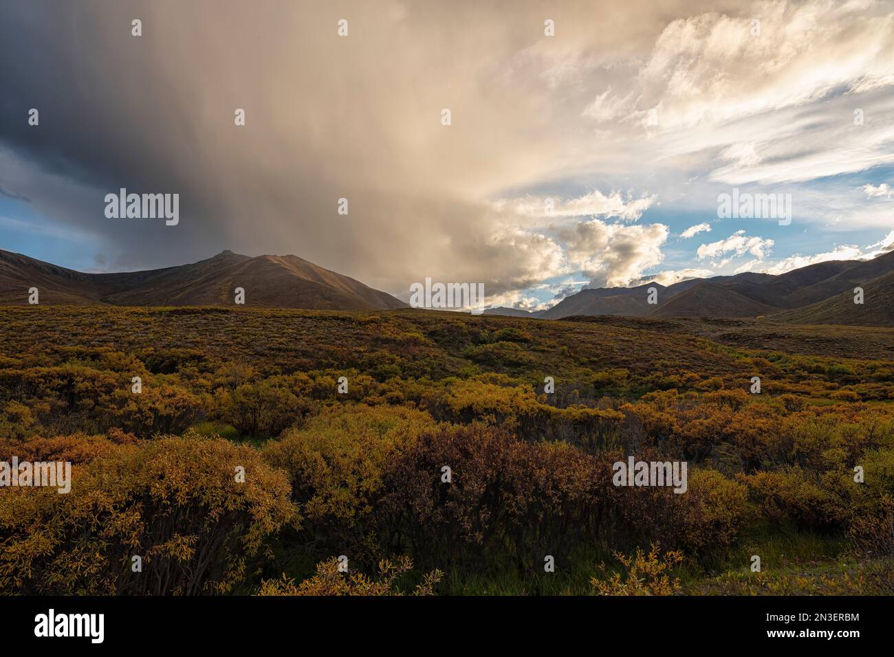 A passing shower hovers over Mount Boyle along the Dempster Highway ...