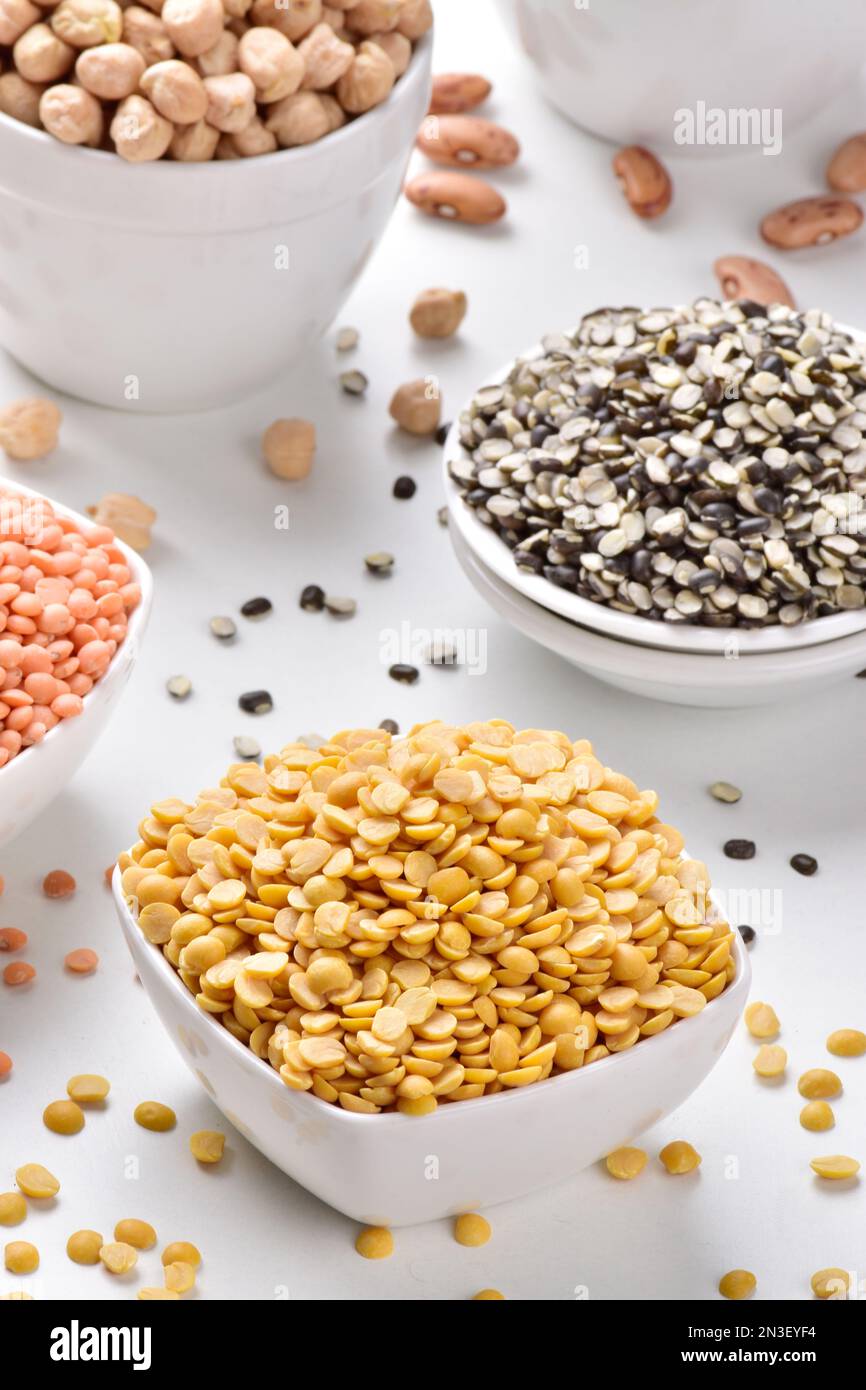 Uncooked toor dal in bowl with multiple legumes and lentils on white ...