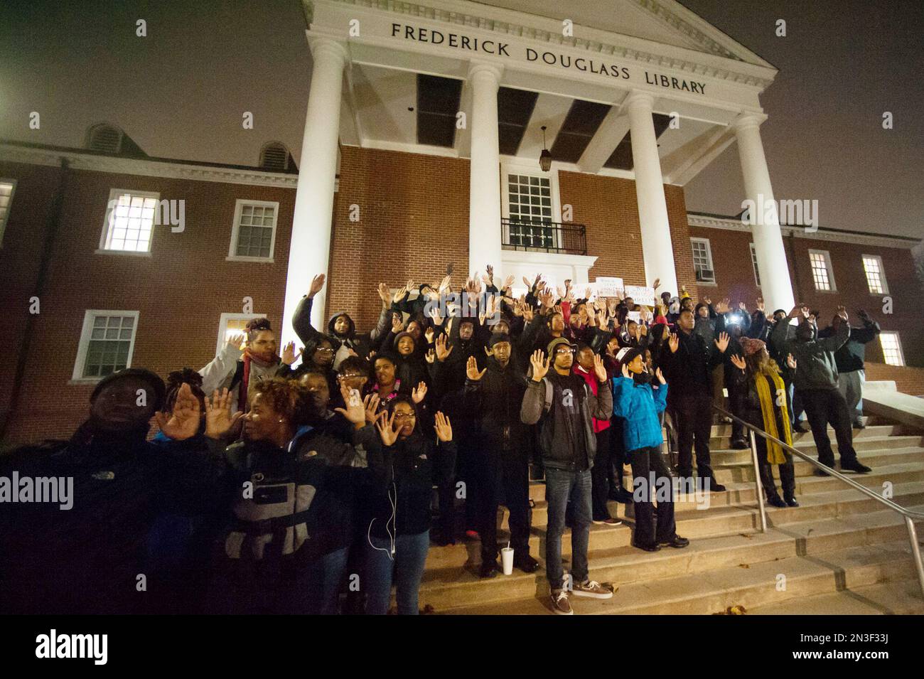 Demonstrators chant "hands up, don't shoot" in front of the Frederick ...